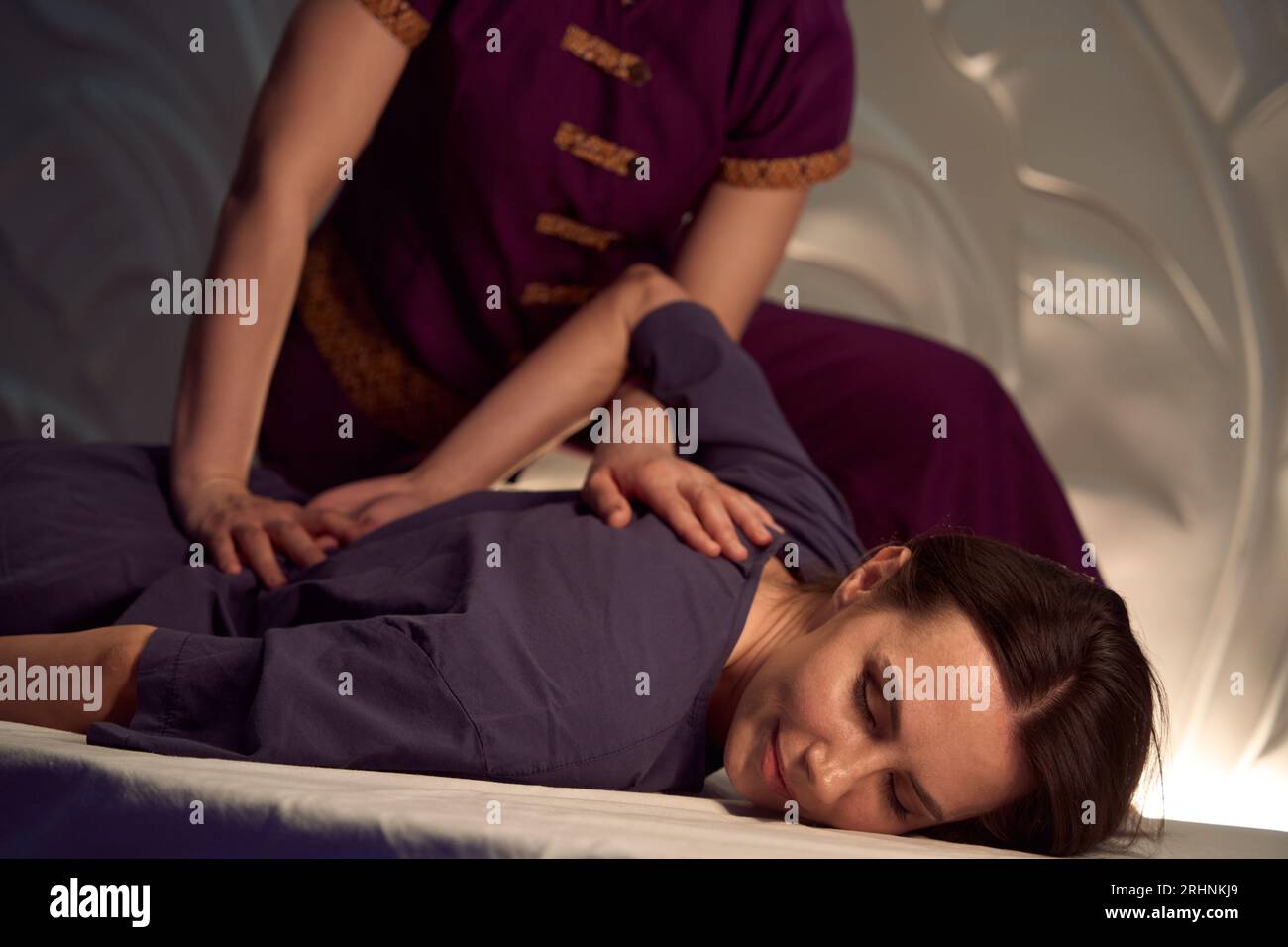 Massage therapist doing diagonal stretch and elongation of patient ...