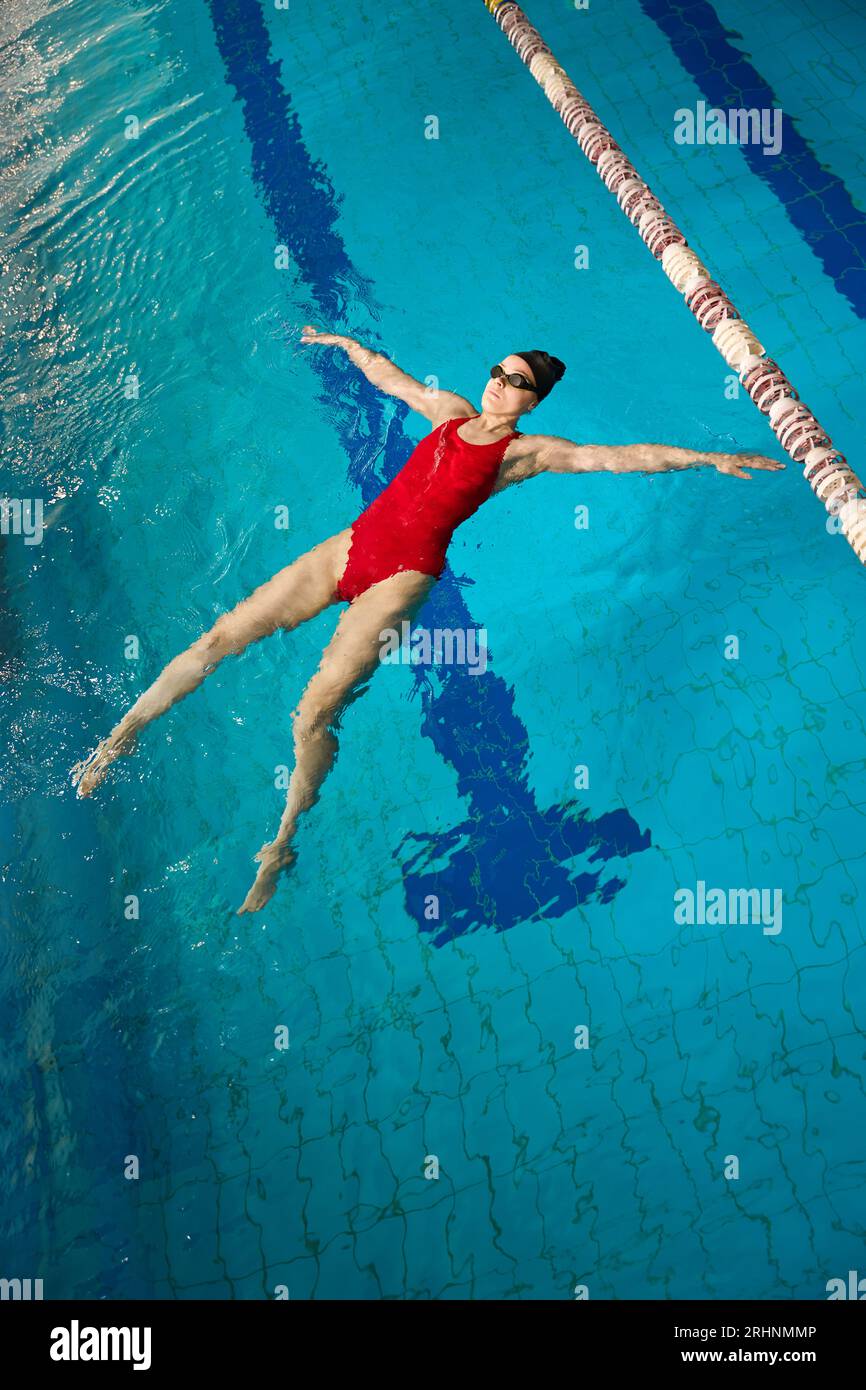 Experienced female athlete doing starfish float in swimming pool Stock ...