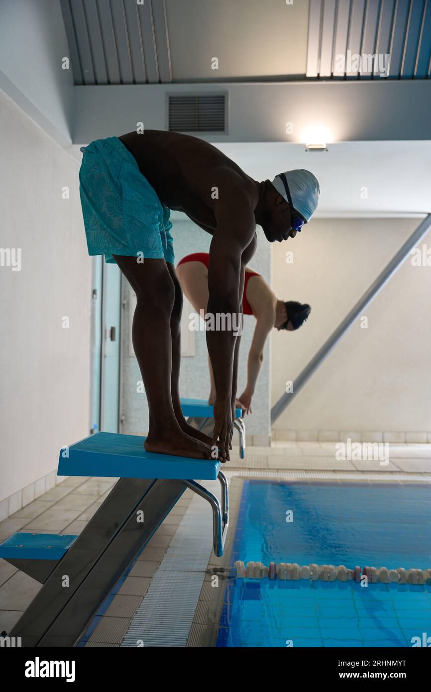 Young swimmers about to dive together into water Stock Photo - Alamy