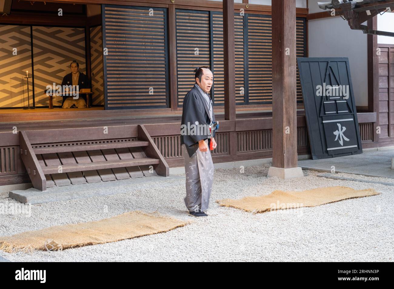 A men dressed in period costume of a high level saumrai with a top knot ...
