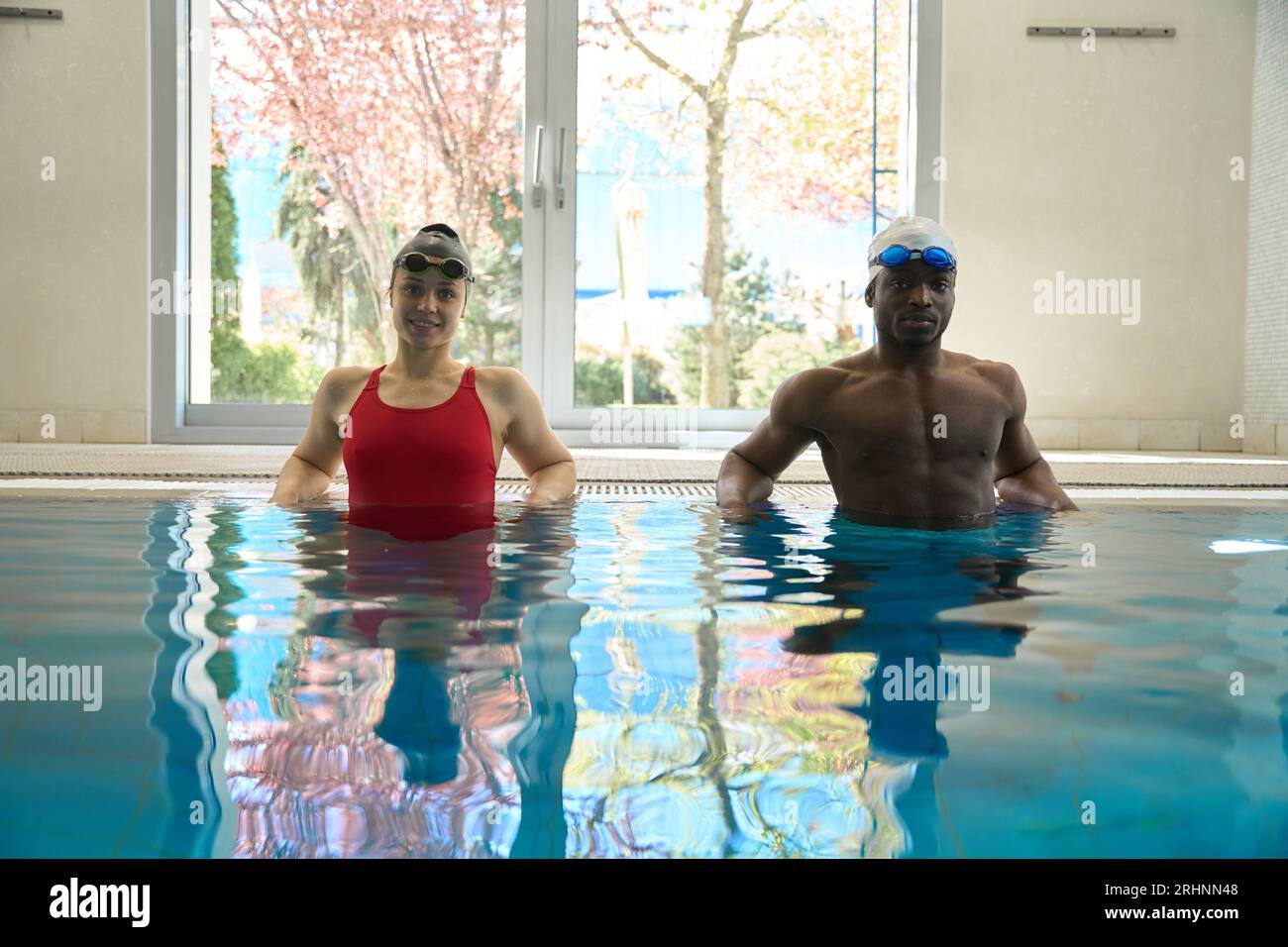 Two swimmers posing for camera in water before swimming workout Stock ...