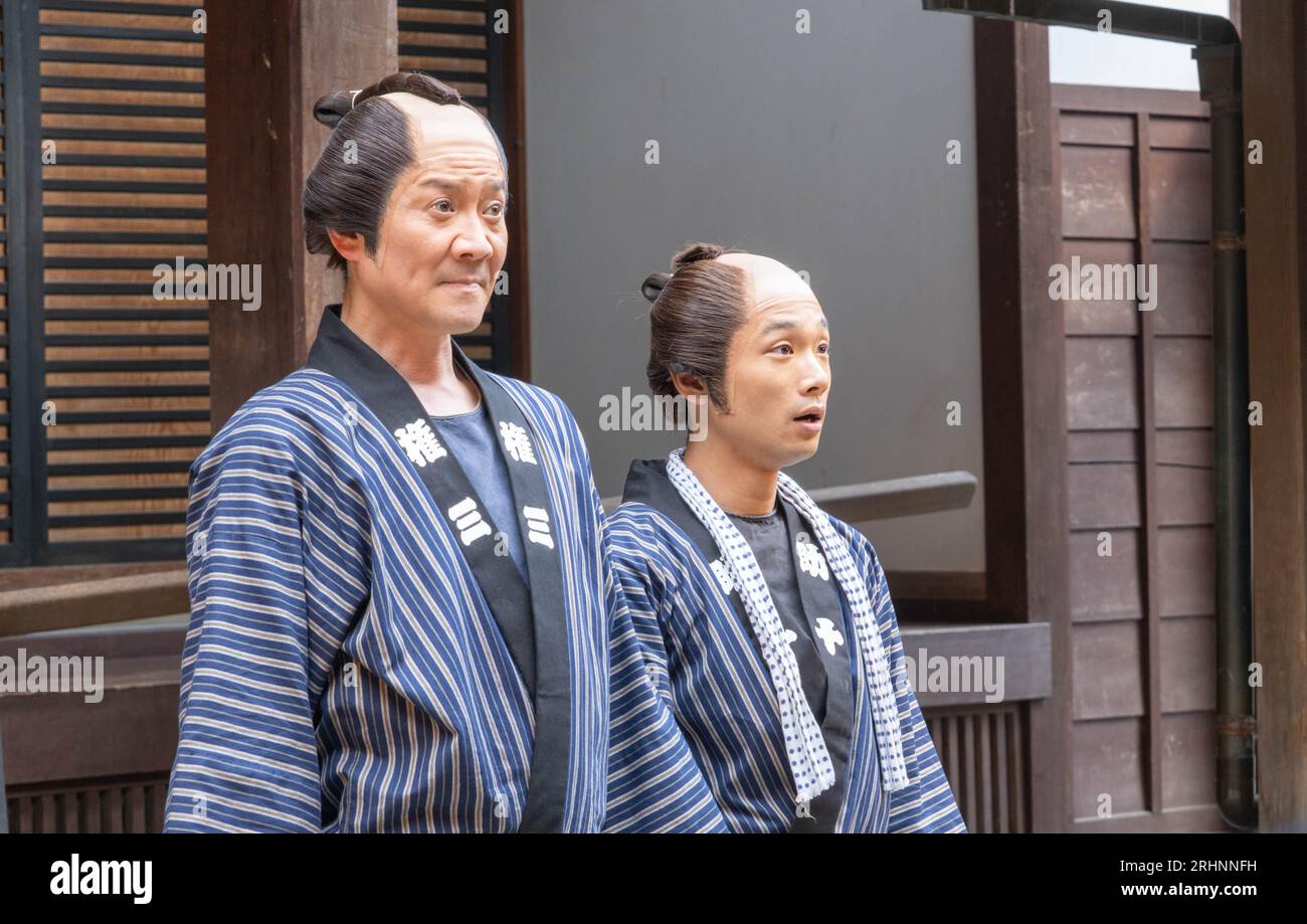 Two men dressed in period costume making an announcement wearing a ...