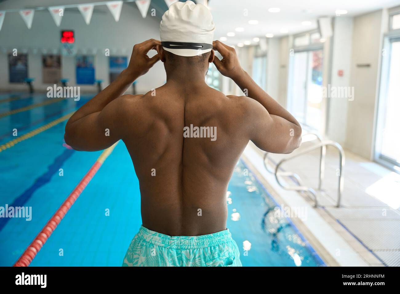 Swimmer putting on protective eyewear before swimming in pool Stock ...