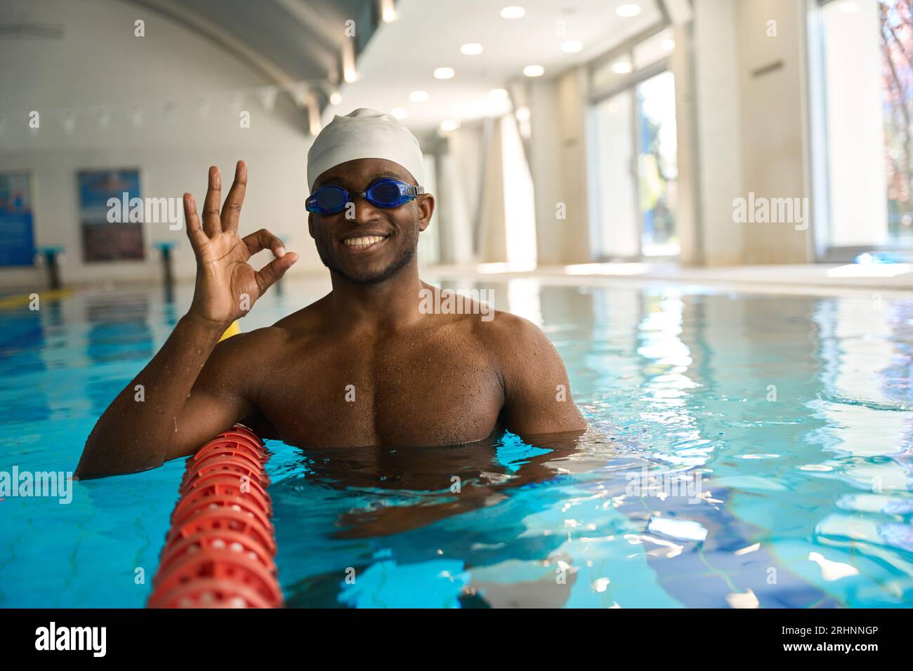 Smiling happy sportsman approving his swimming pool training before ...