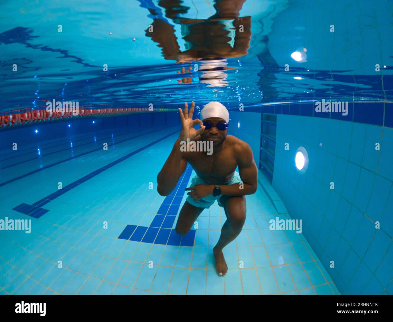 Professional swimmer approving his underwater swimming workout in pool ...