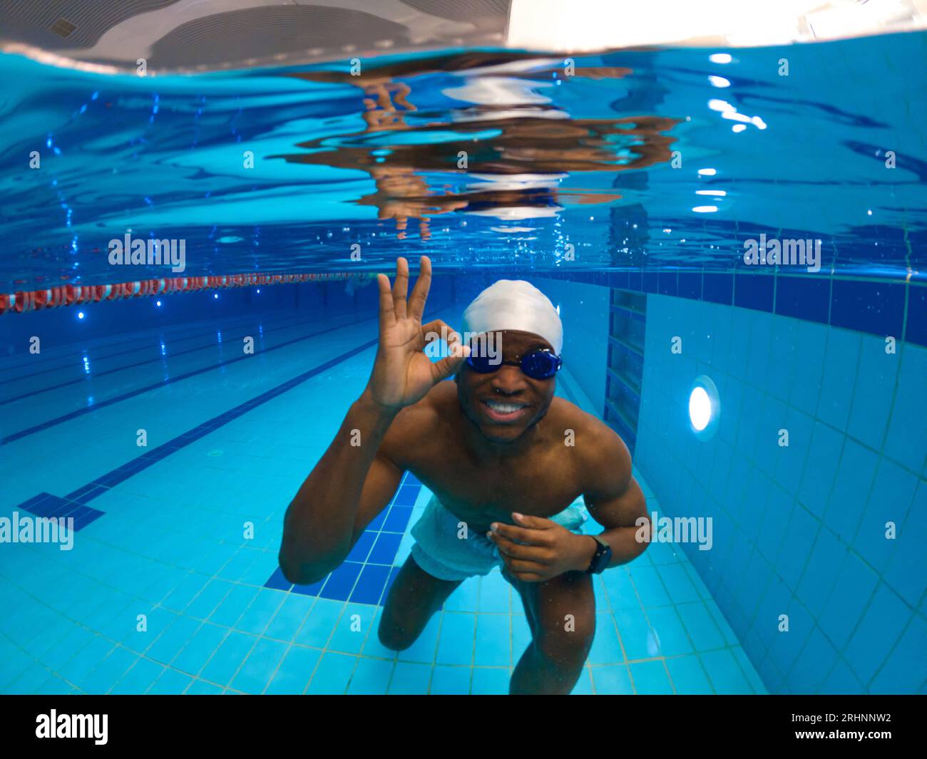 Cheerful athlete approving his underwater workout in swimming pool ...