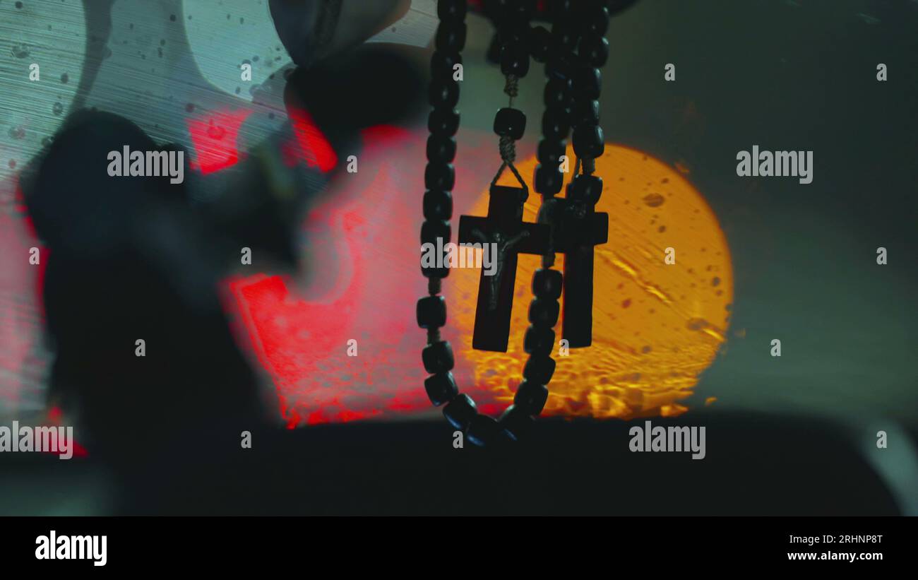 Christian cross on display at car windshield while raining in ...