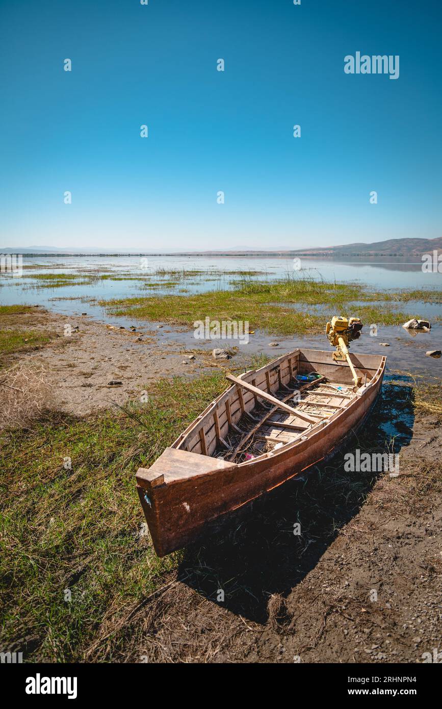 Abandoned row boat on cracked soil on lake bed dried up due to global ...