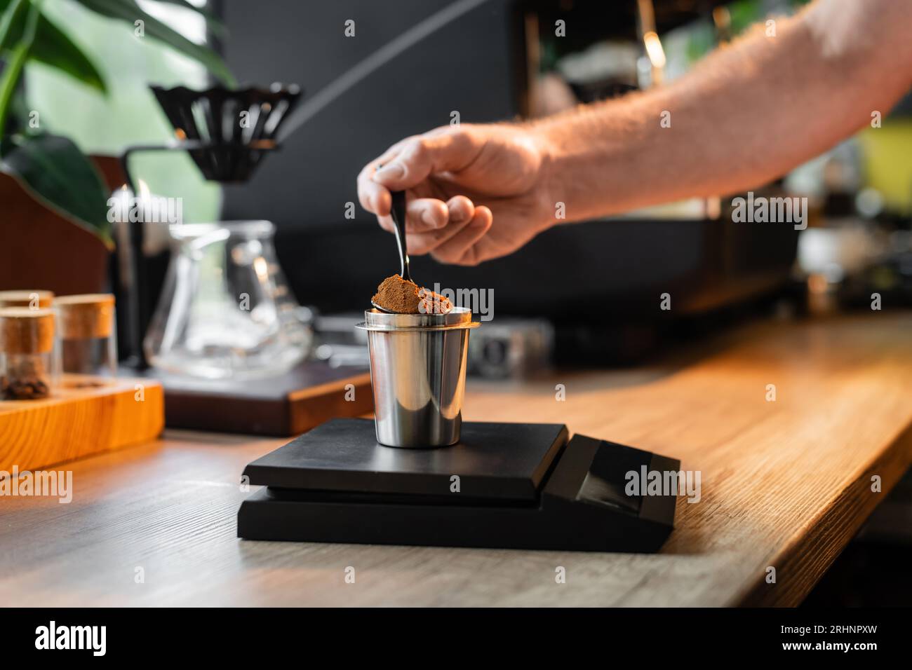 cropped view of barista pouring coffee in beaker on electronic scales ...