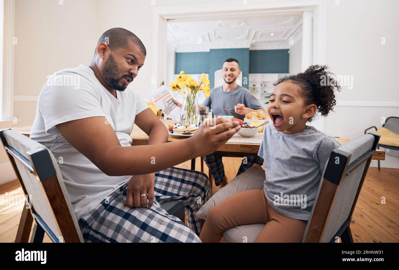 Gay couple, breakfast and father feeding child meal, food or morning ...