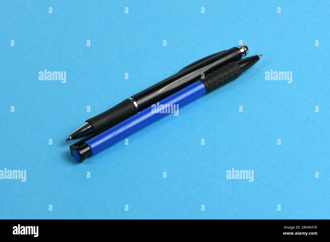Business blue and black automatic ballpoint pen isolated on blue. High ...