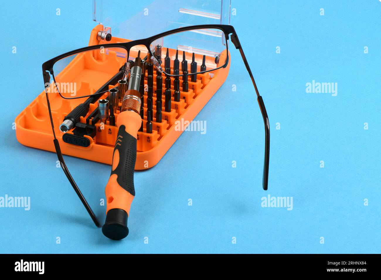 Set of screwdriver bits for repair reading glasses isolated on blue ...