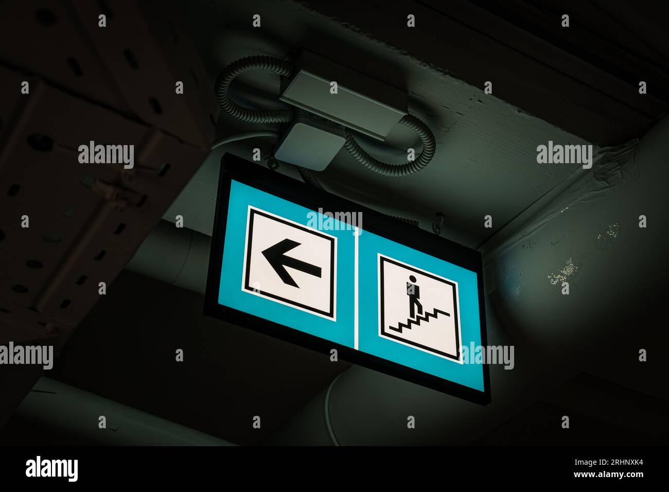 Green And Blue Illuminated Directional Sign Leading To Staircase Stock ...