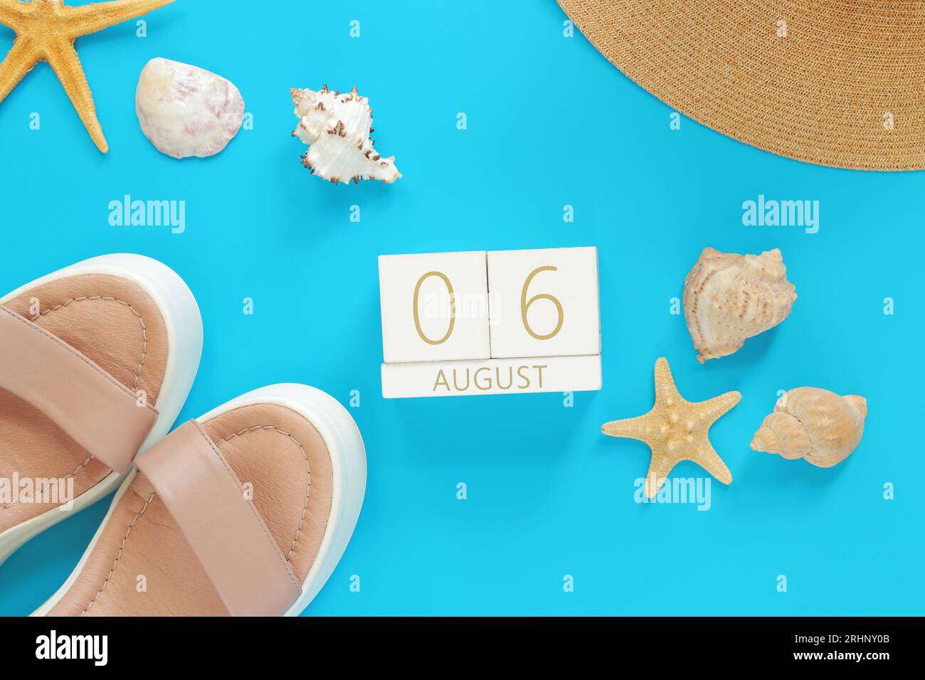 August 06. Wooden calendar on a blue background with summer accessories ...