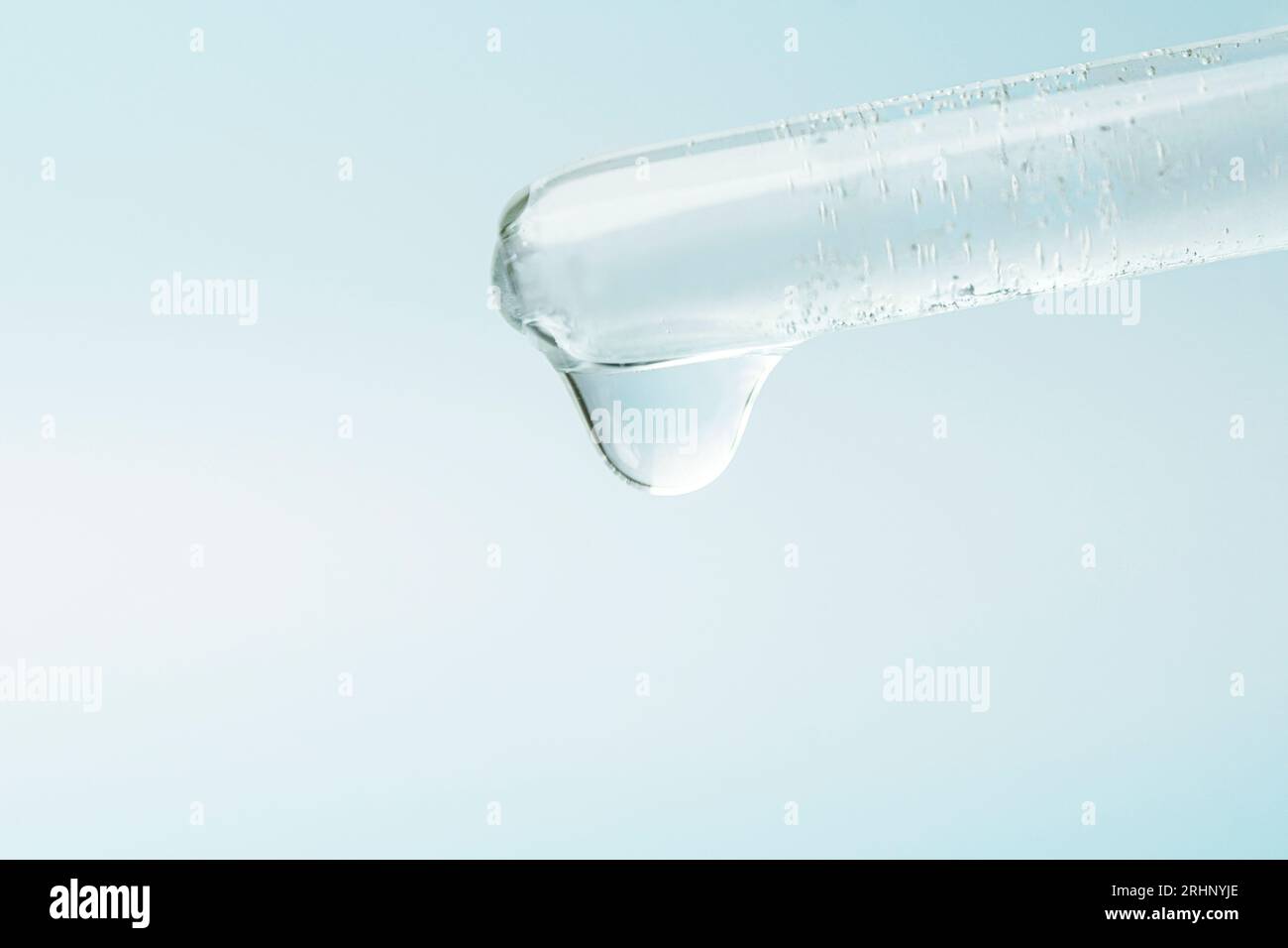 Pipette dropping liquid into glass tubes. Laboratory glassware with ...