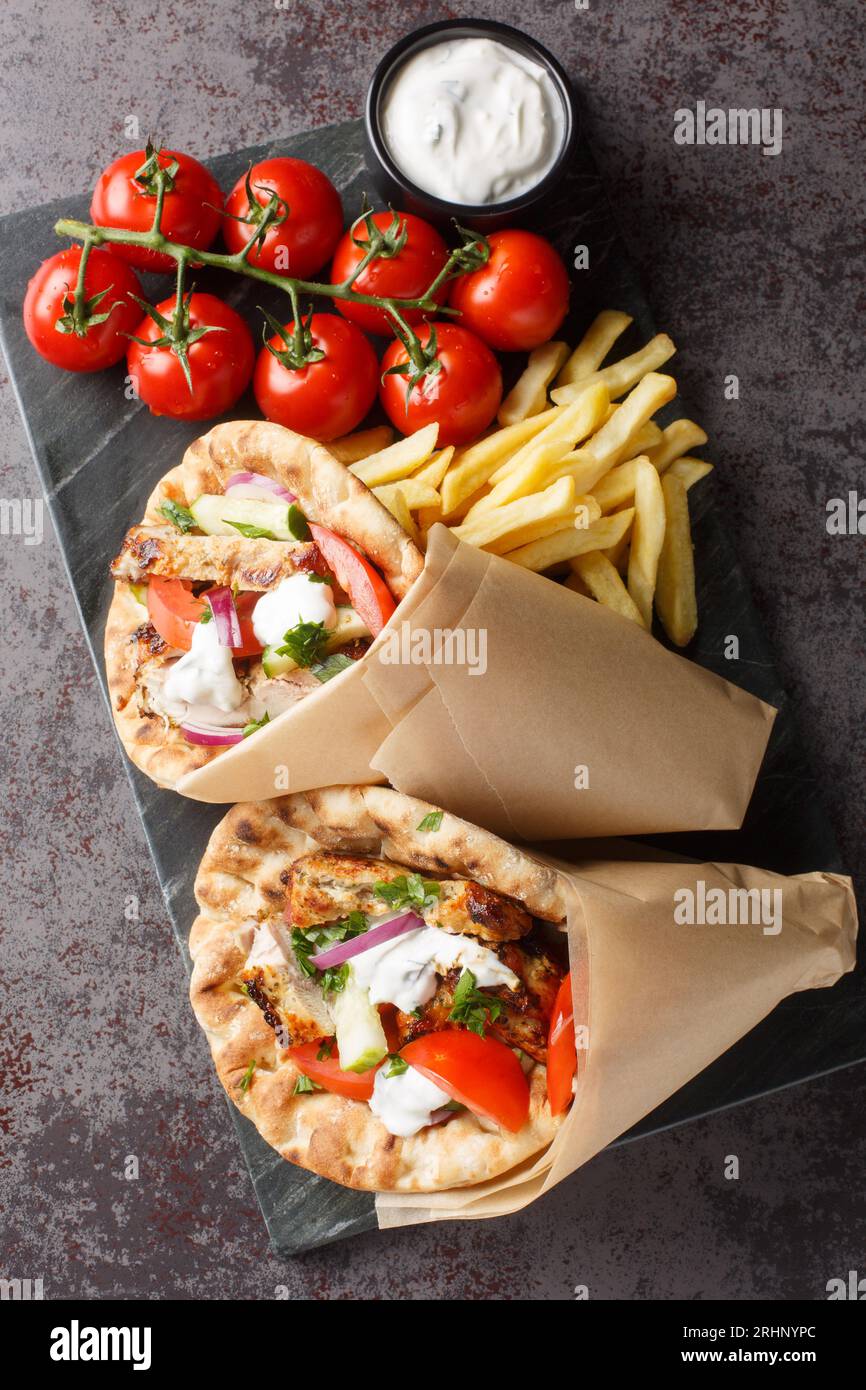 Tasty wrapped greek chicken gyros with vegetables, french fries and ...