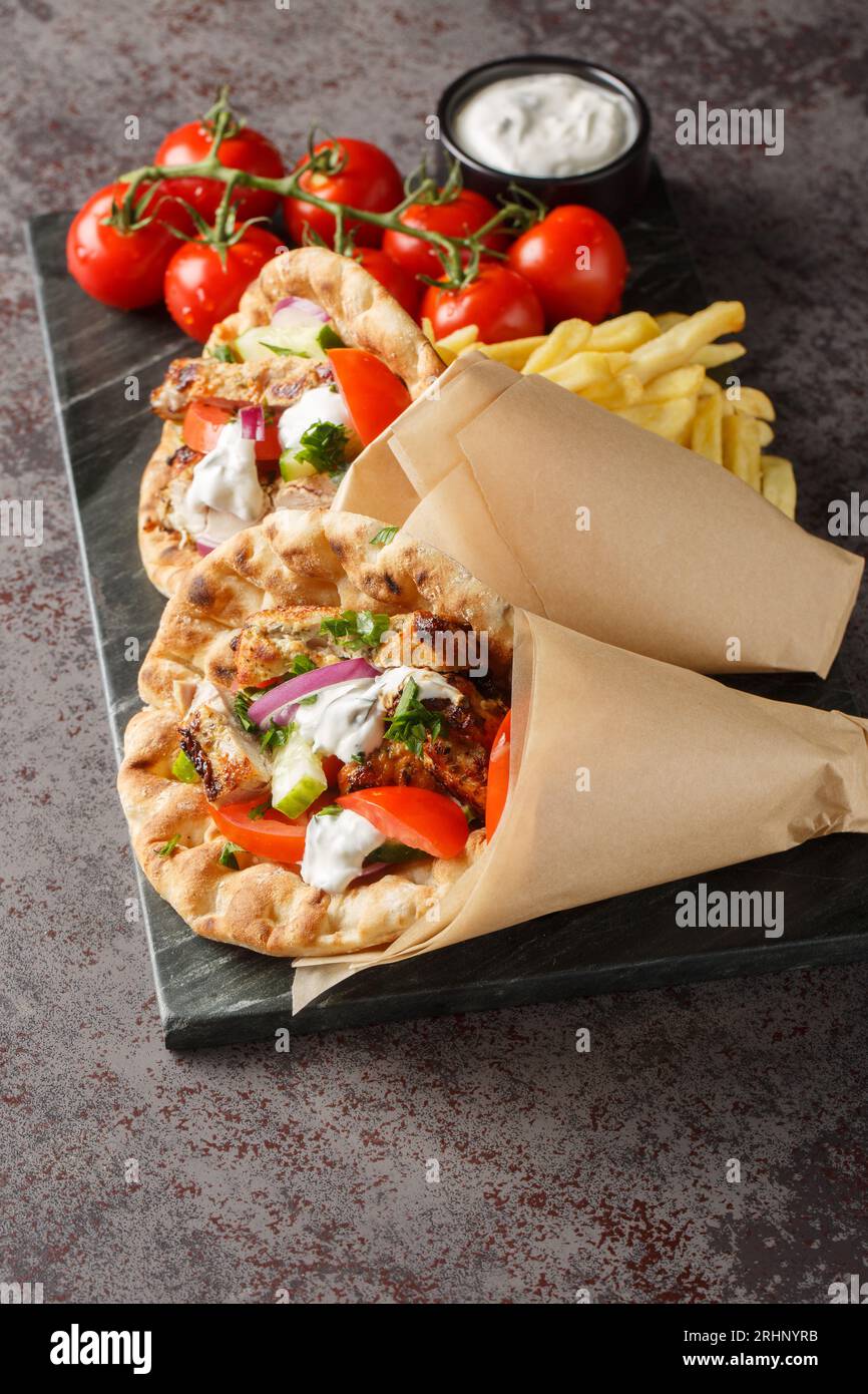 Tasty wrapped greek chicken gyros with vegetables, french fries and ...