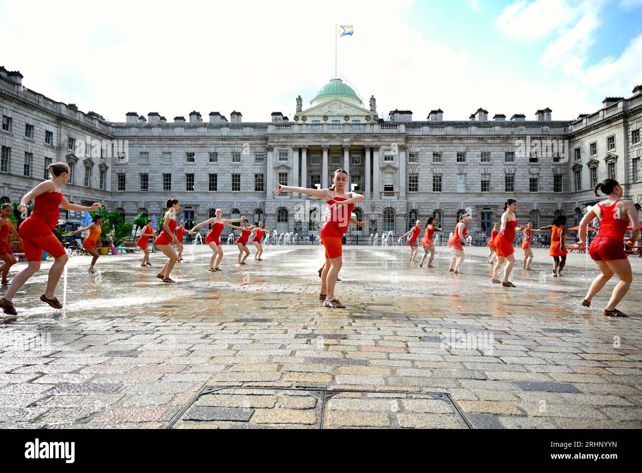 22 all-female dancers in vivid orange costumes designed by Ursula ...