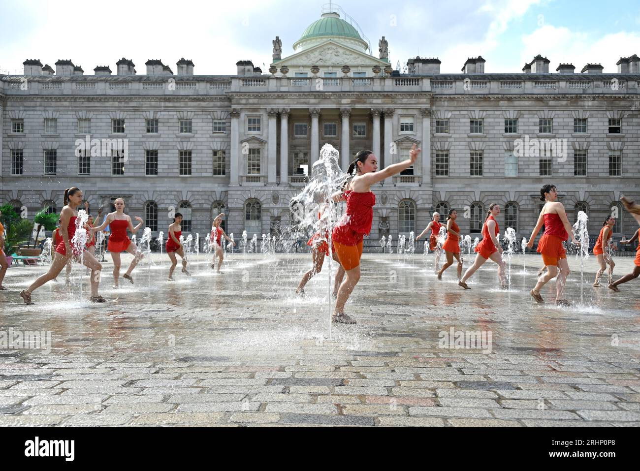 22 all-female dancers in vivid orange costumes designed by Ursula ...