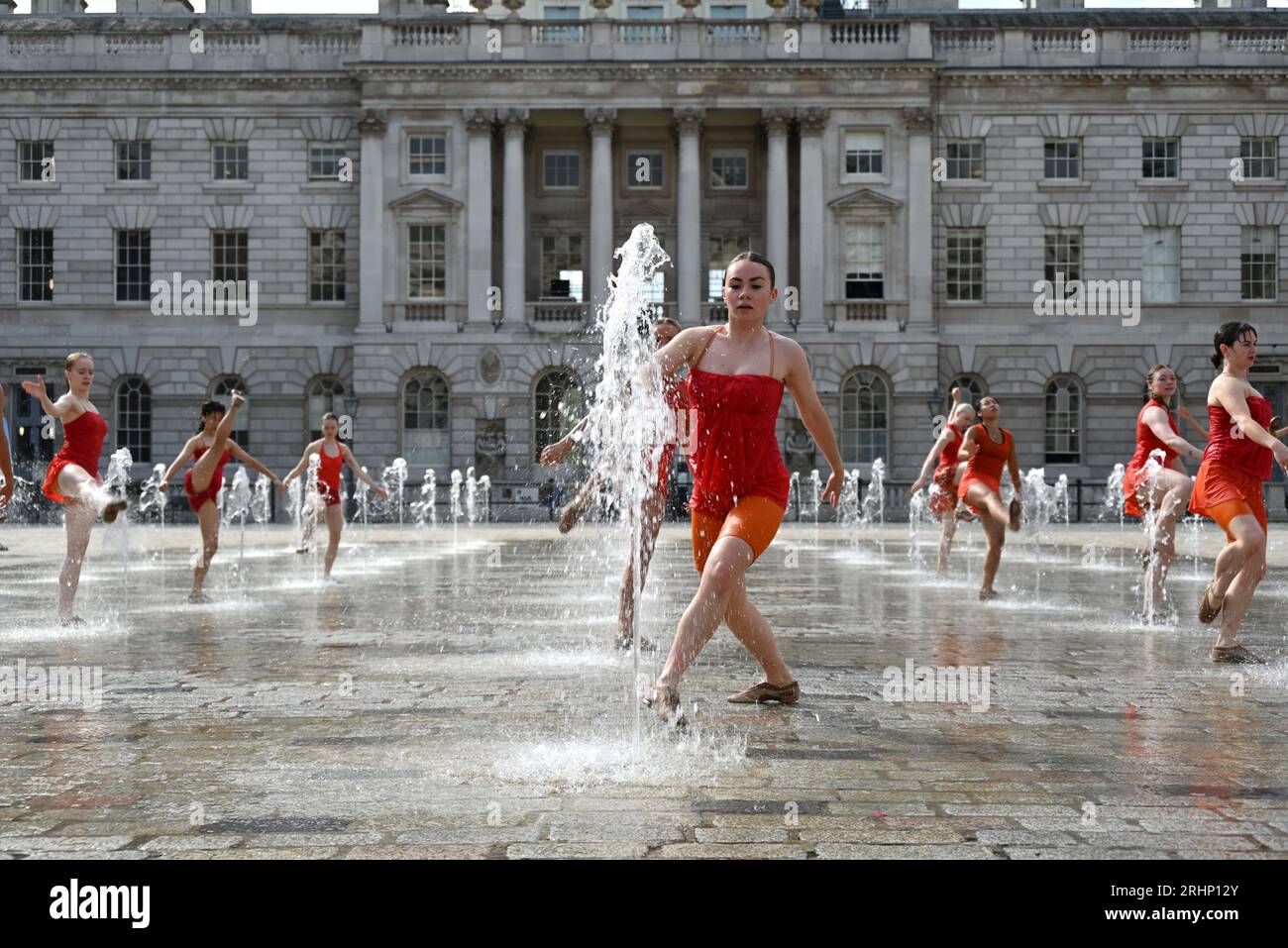 22 all-female dancers in vivid orange costumes designed by Ursula ...
