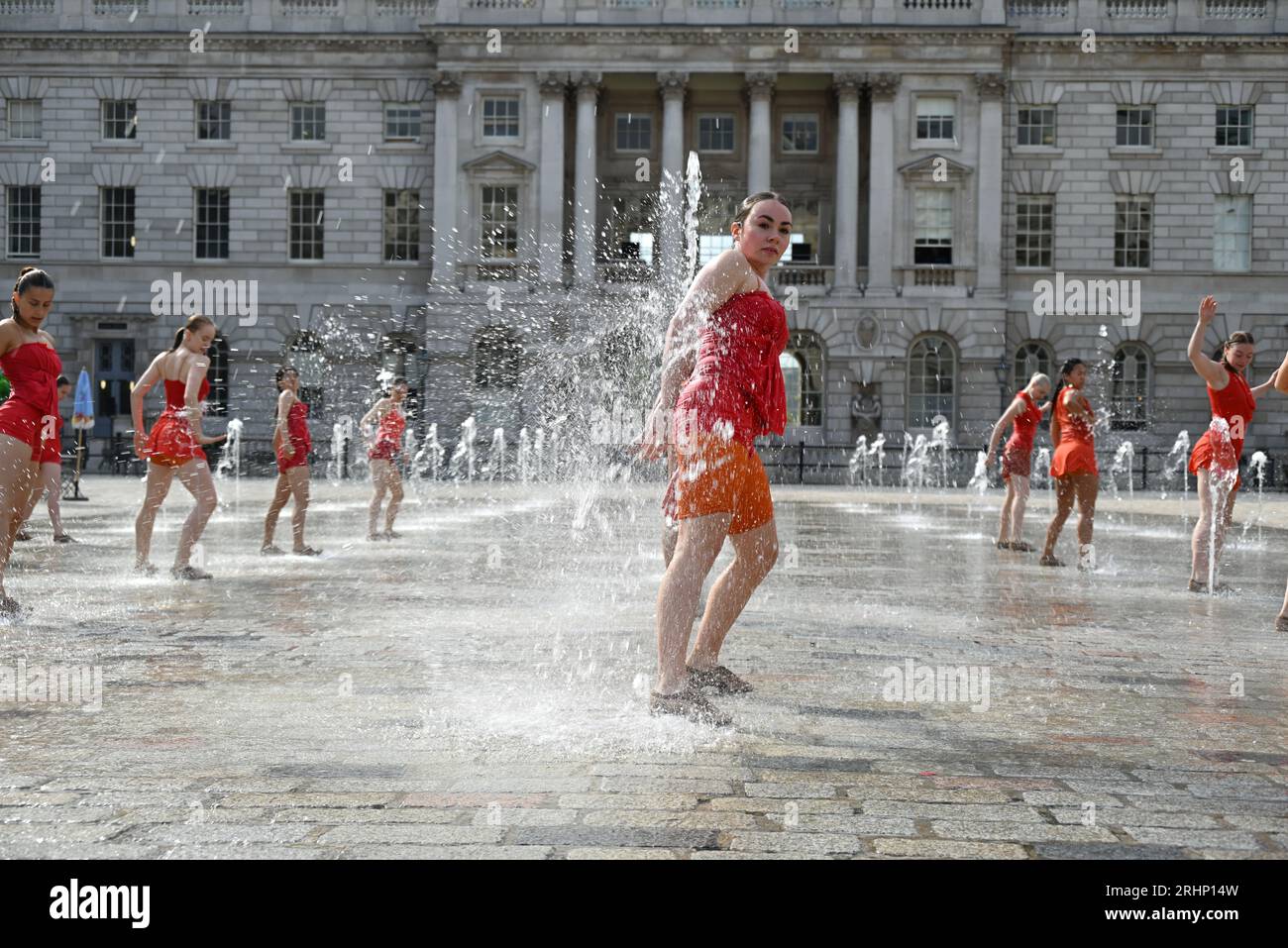 22 all-female dancers in vivid orange costumes designed by Ursula ...