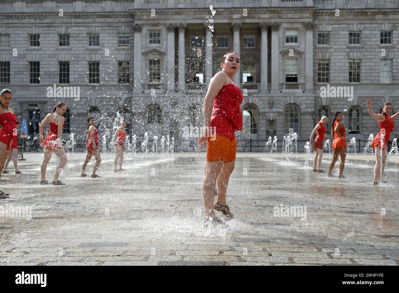 22 all-female dancers in vivid orange costumes designed by Ursula ...