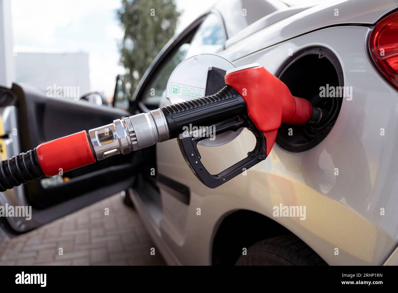 View of the fuel refueling gun in the neck of the gas tank of the car ...