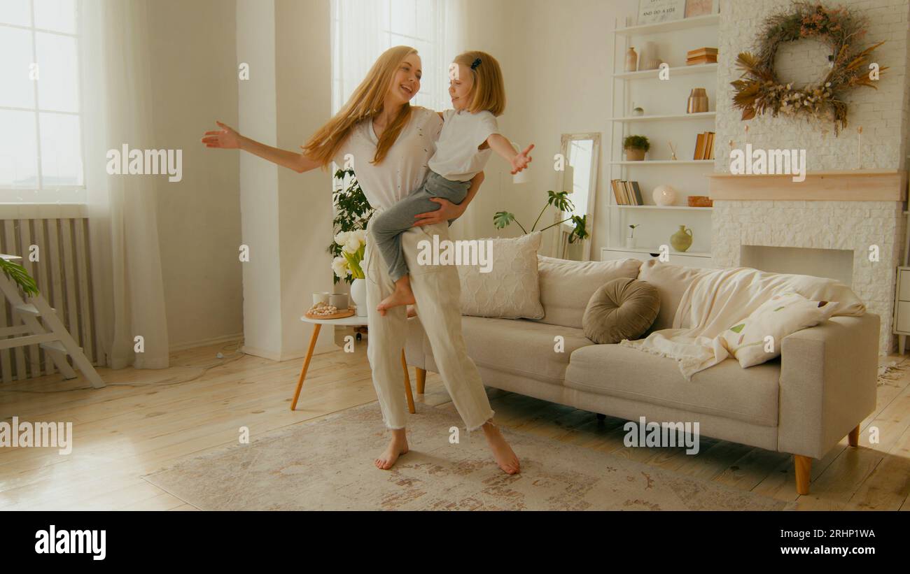 Lovely Caucasian mother mum cuddle carrying little daughter child girl ...