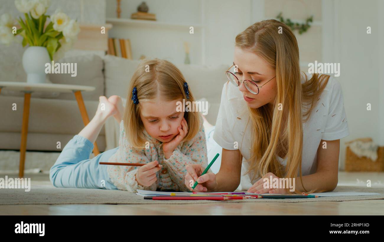 Caucasian mum nanny babysitter helping cute kid daughter teaching ...