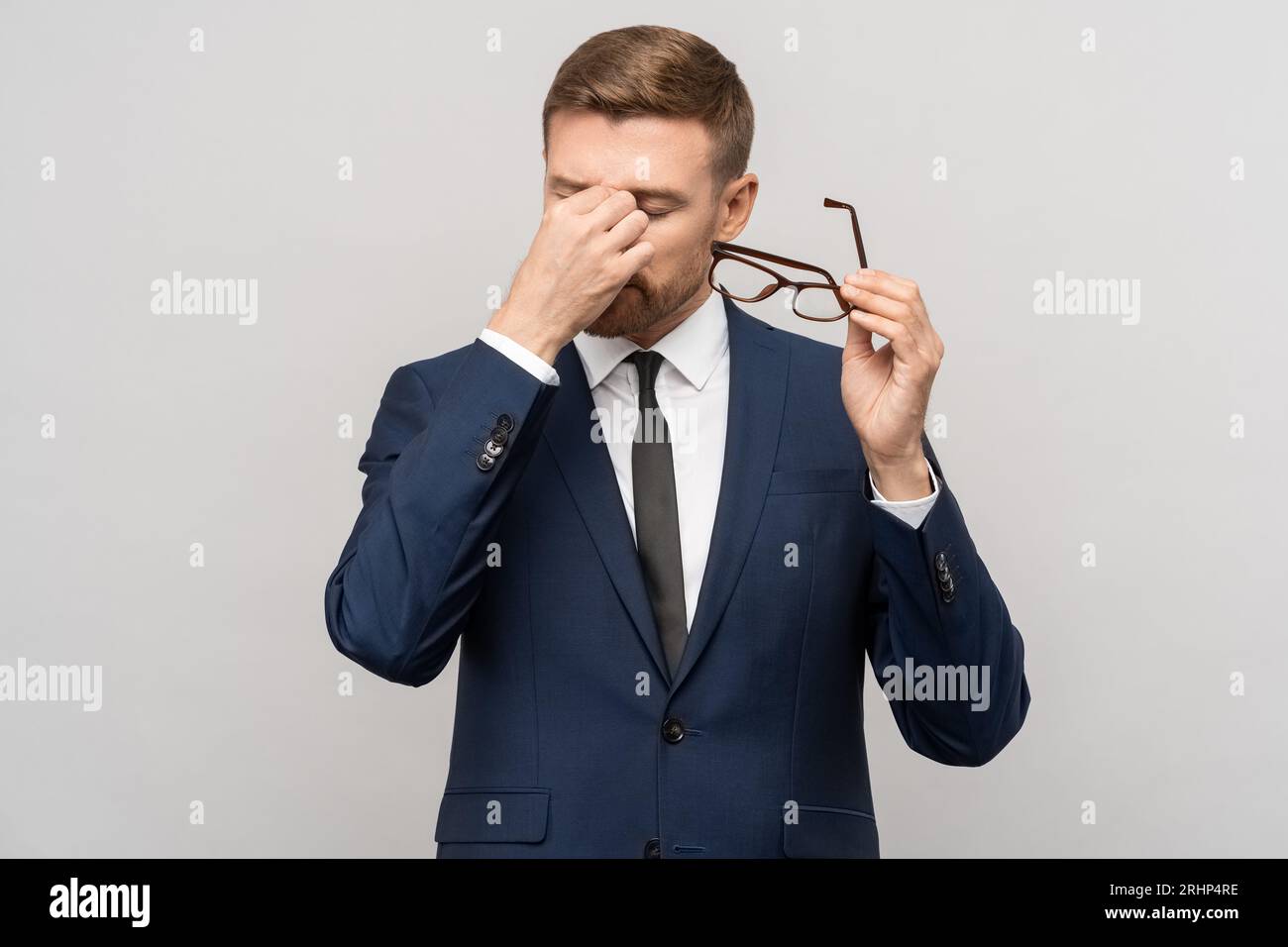 Businessman takes off glasses, massaging eyelids of eyes. Overworked ...