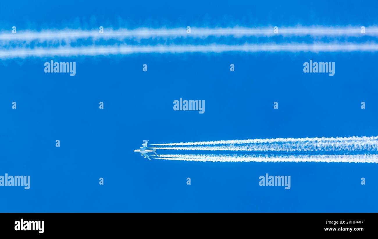 Four engined airplane during flight with condensation trails Stock ...