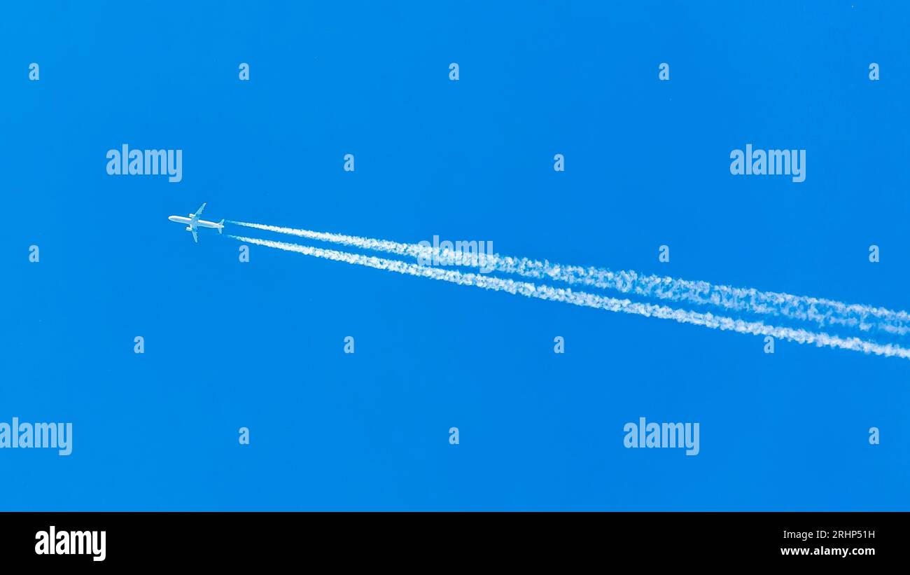 Two engined airplane during flight with condensation trails Stock Photo ...