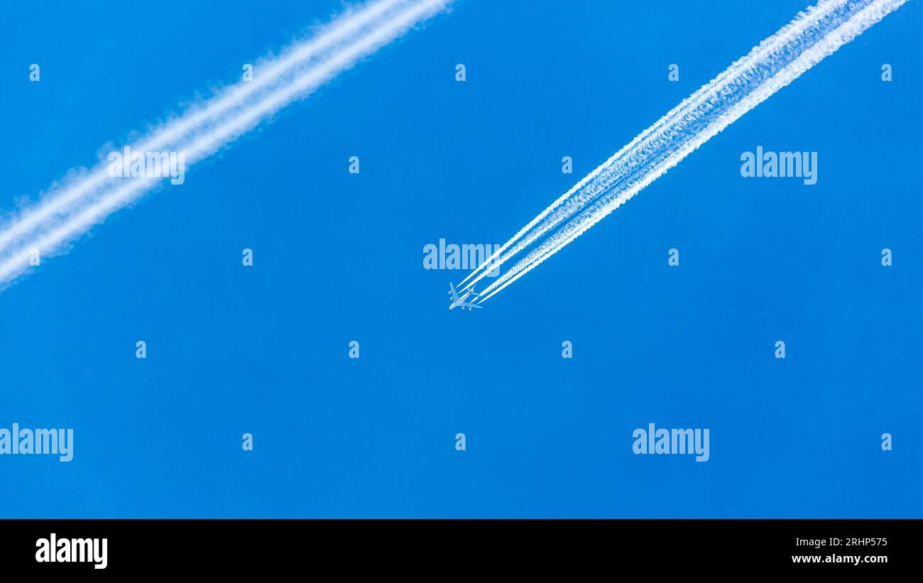 Two engined airplane during flight with condensation trails Stock Photo ...
