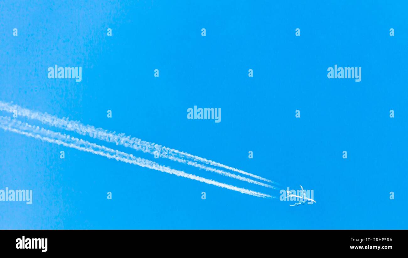 Four engined airplane during flight with condensation trails Stock ...
