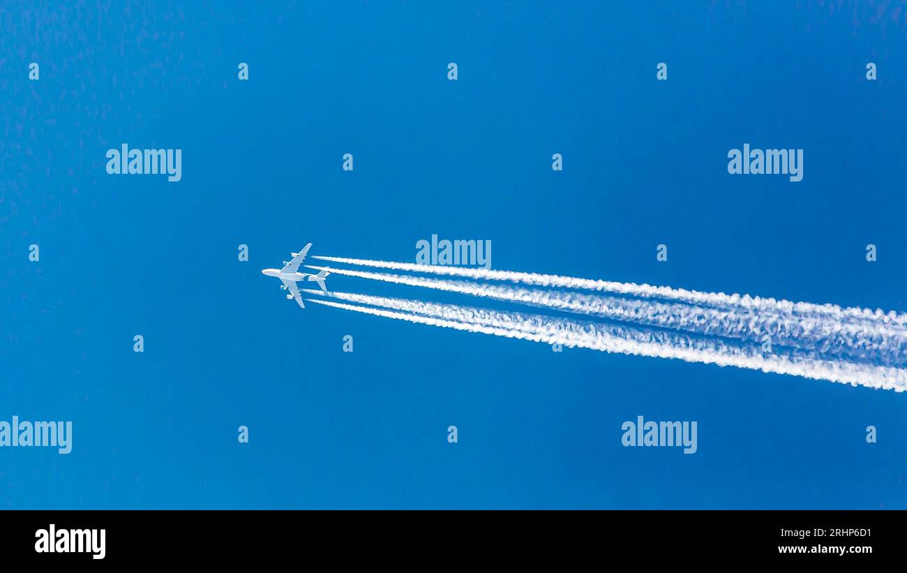 Four engined airplane during flight with condensation trails Stock ...