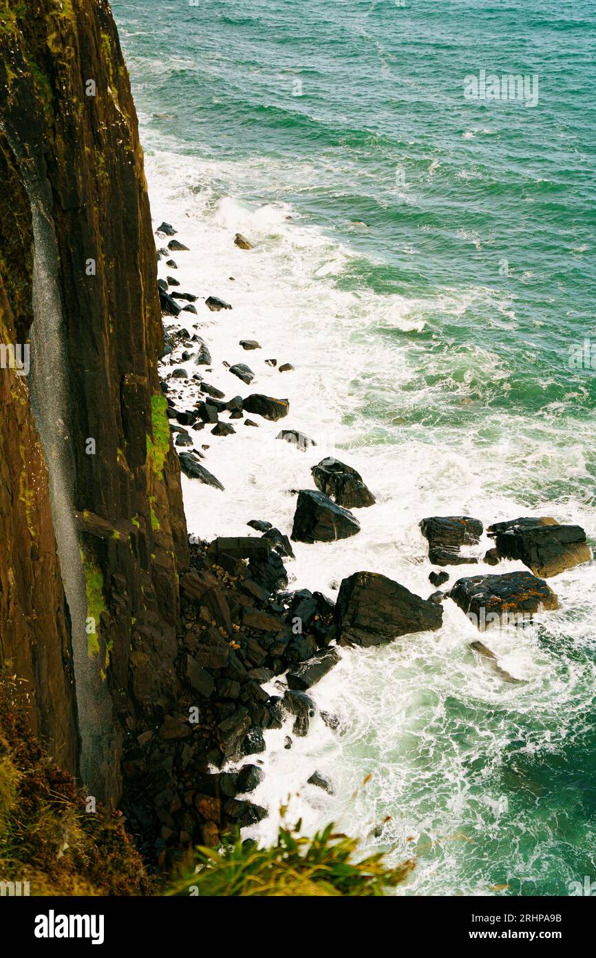 Close of Kilt Rock cliff with waterfall flowing water into the sea with ...