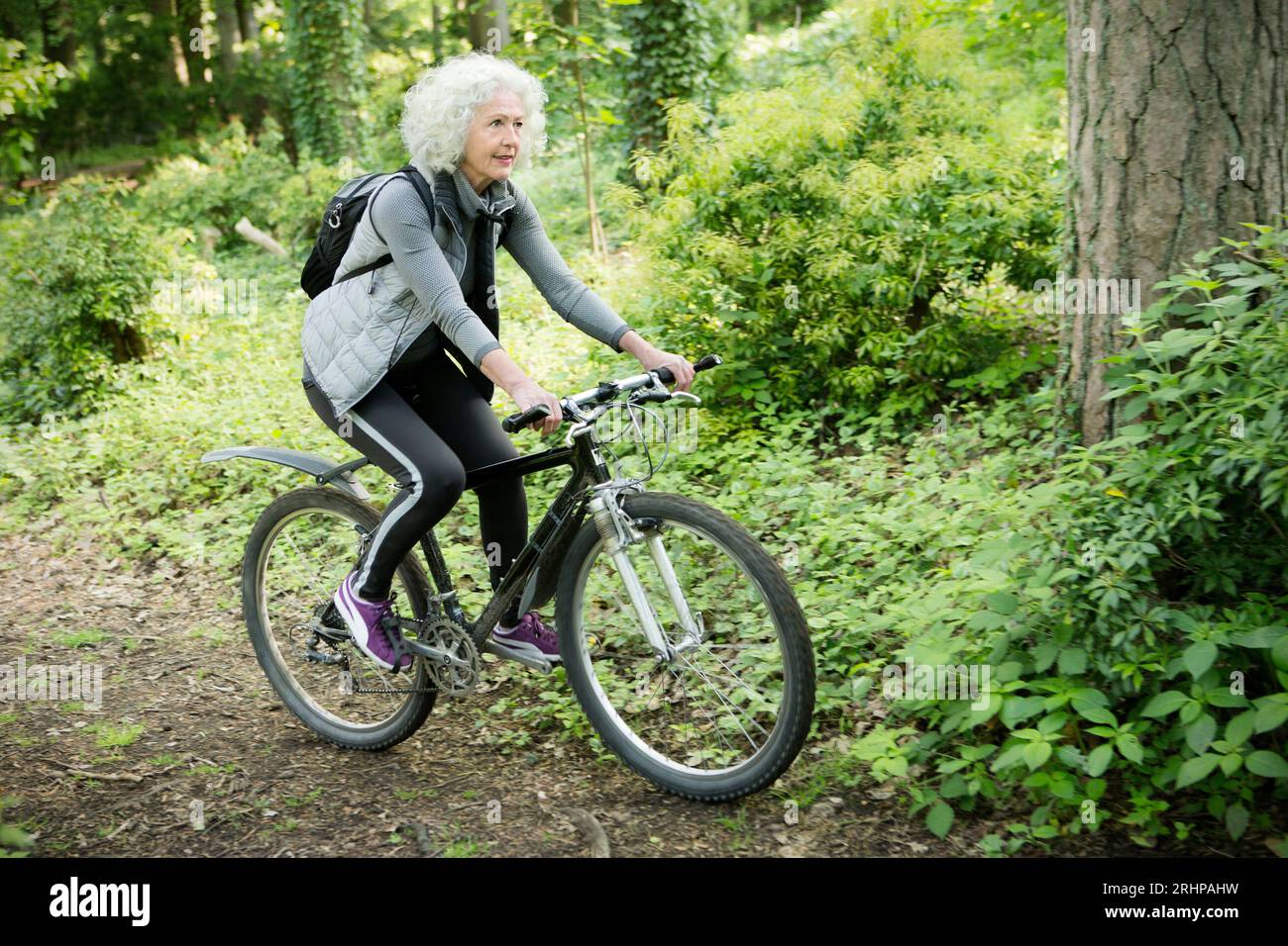 Elderly woman riding bicycle Stock Photo - Alamy