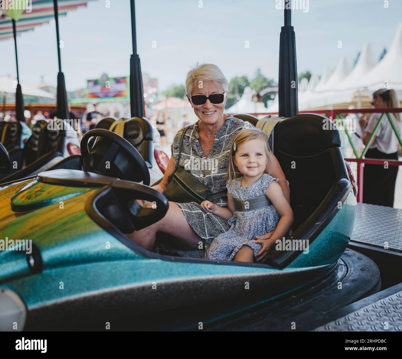 Grandmother rides bumper cars together with her granddaughter Stock ...
