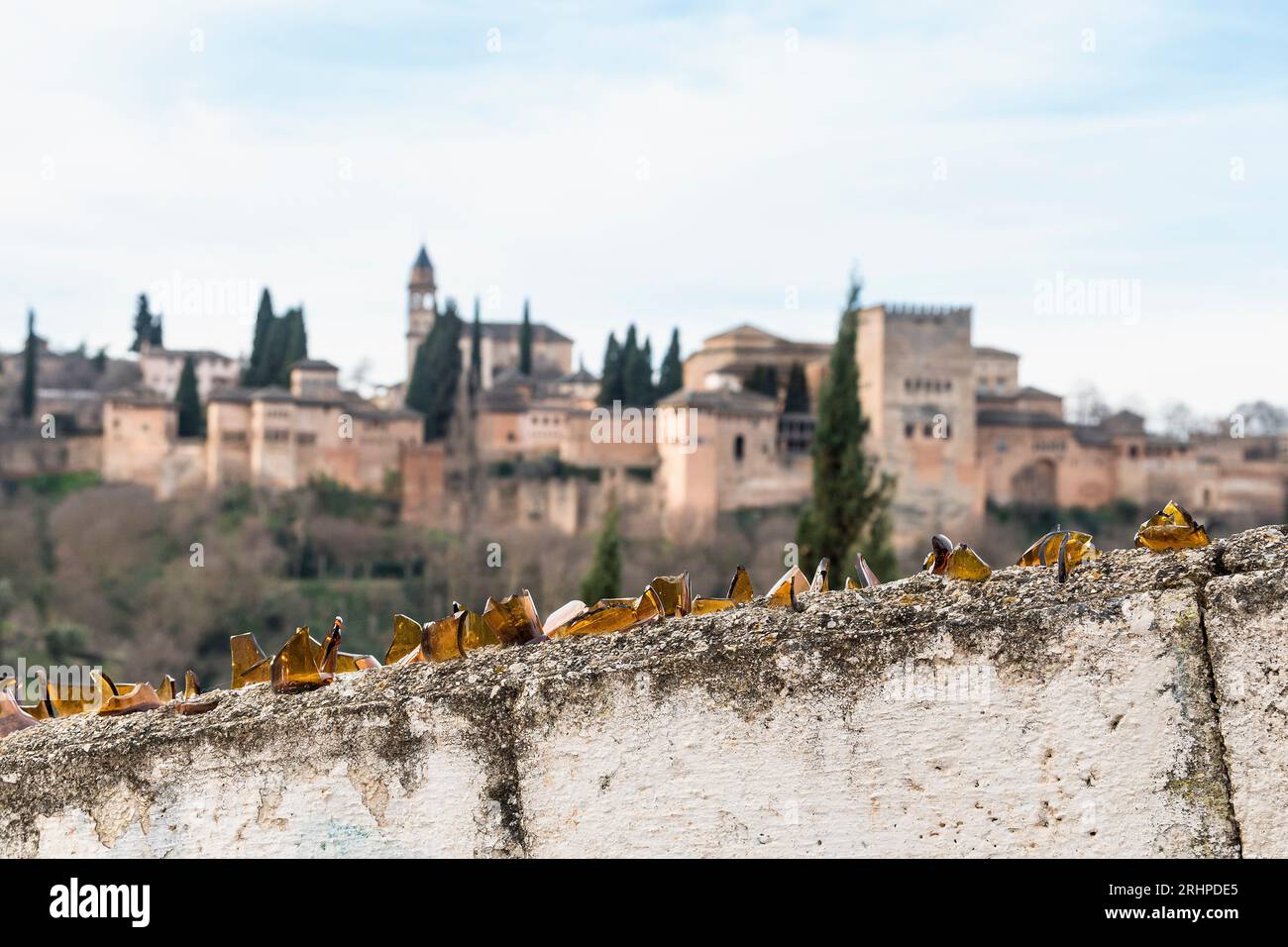 Spain, Andalusia, Granada, wall with broken glass, behind it the ...