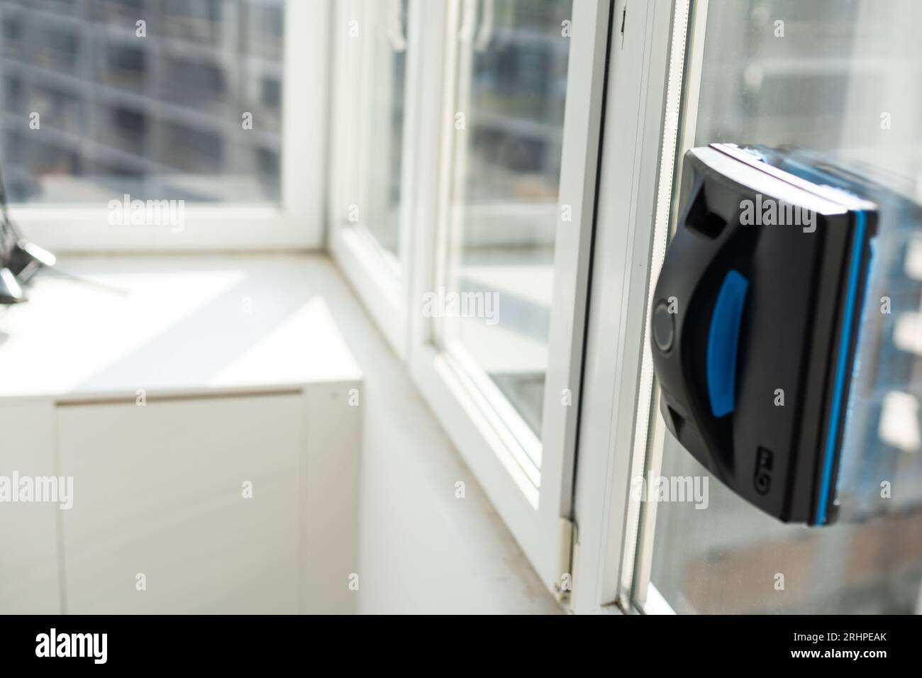 The white robotic window cleaner uses a brush and vacuum for a thorough ...
