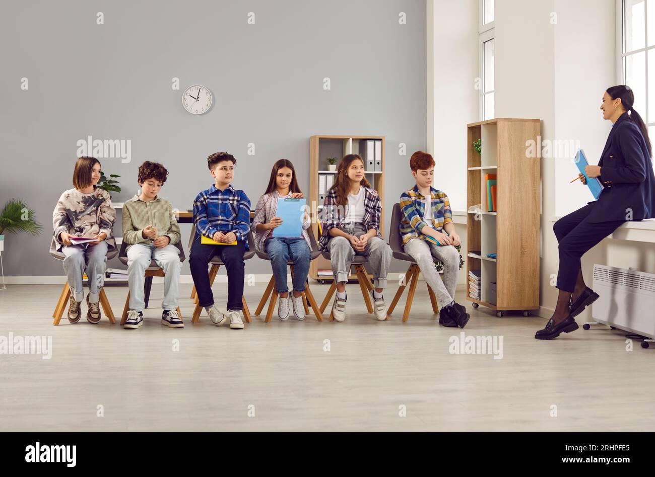 Smiling female teacher talking to school children in classroom Stock ...