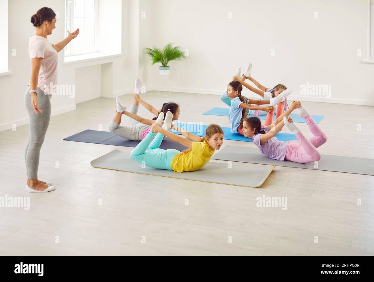 Group of flexible children doing gymnastic exercises on gym floor at ...