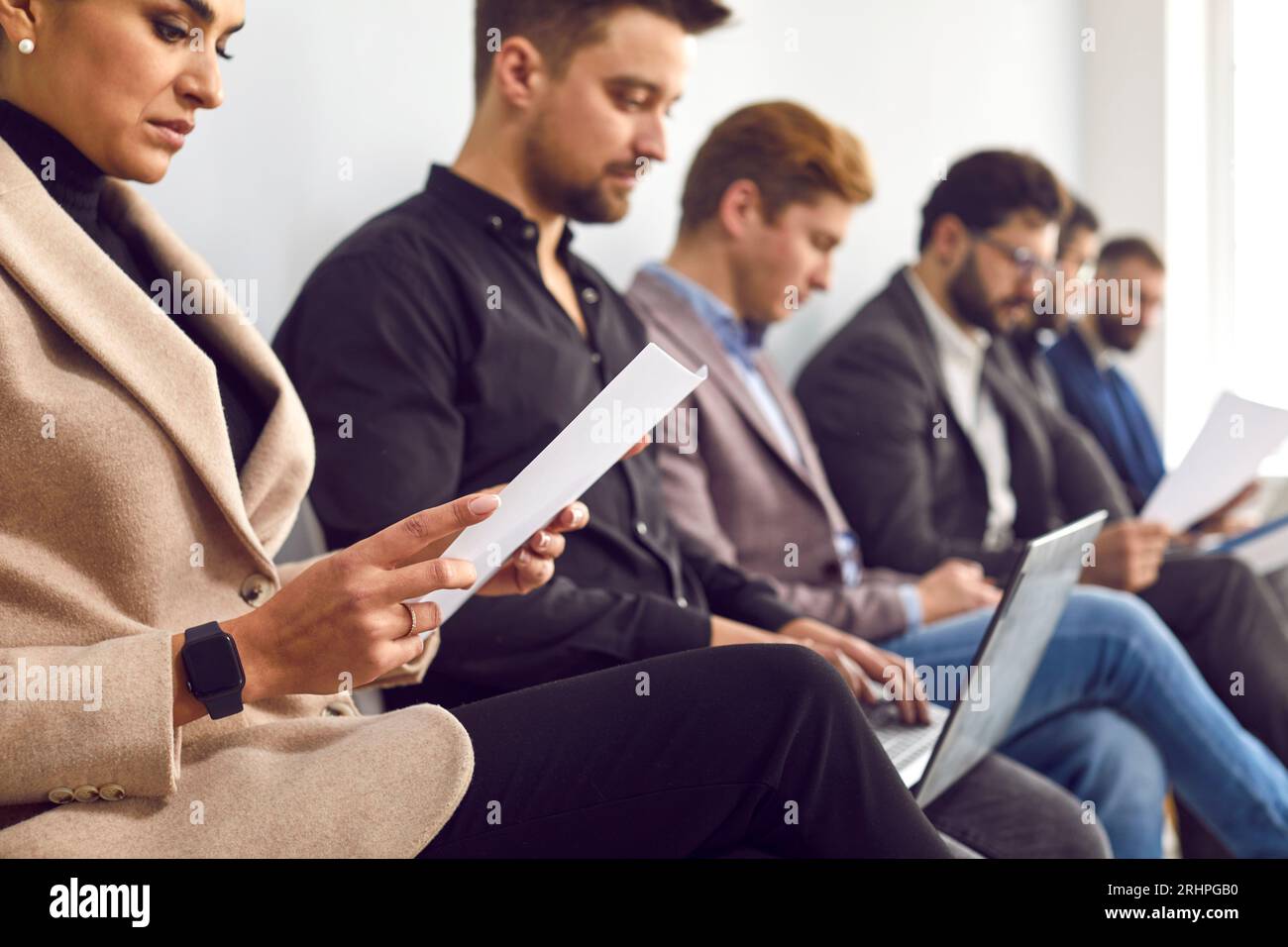 Group of people waiting in line in the office, reading documents and ...