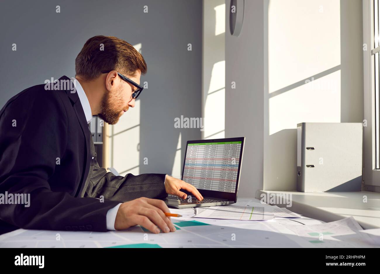 Man works with cadastral maps and city plans and uses spreadsheets on ...