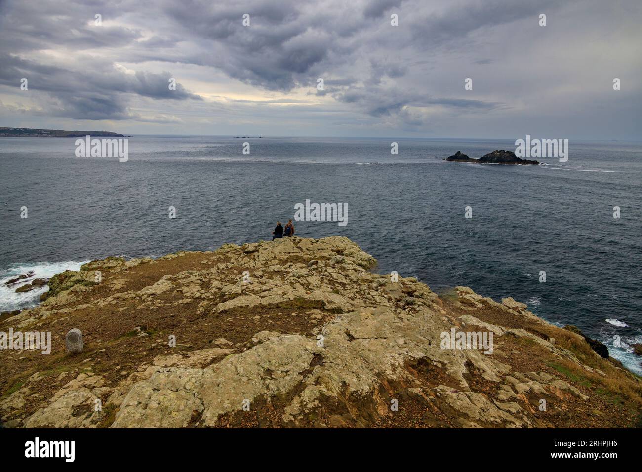 Two visitors looking south from Cape Cornwall towards Land's End and ...