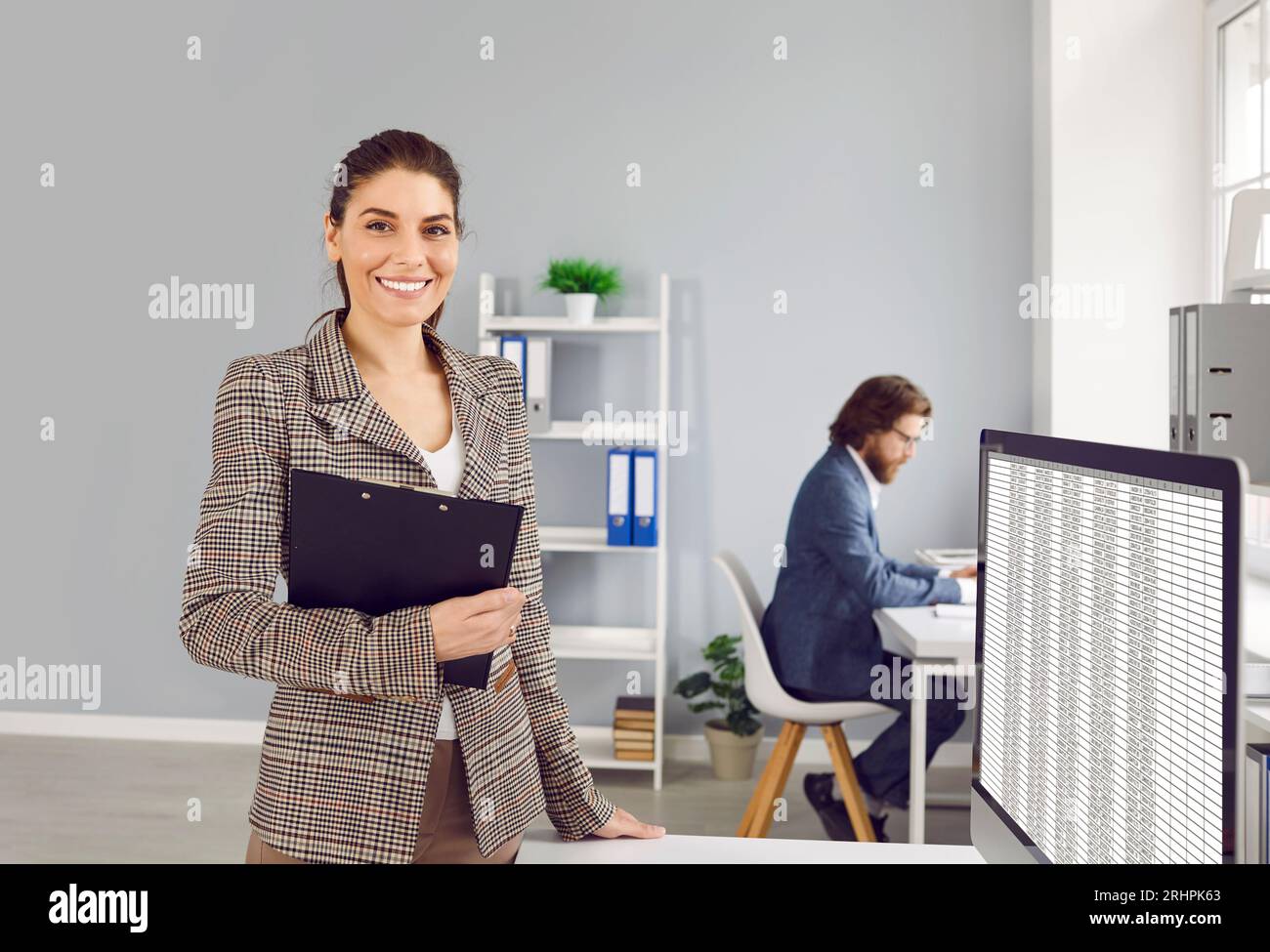Portrait of friendly smiling female accountant or financial analyst at ...