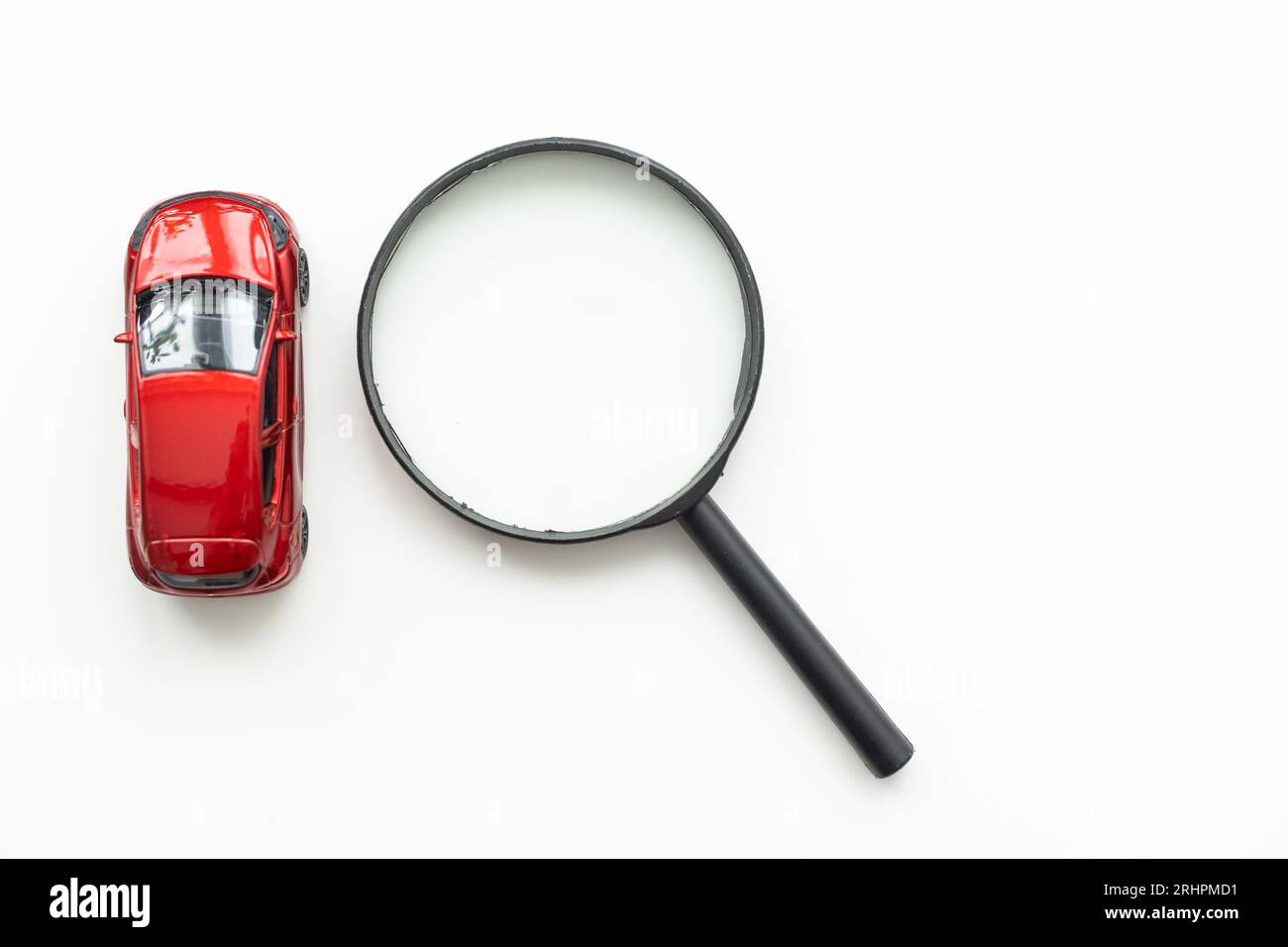 Toy car model and magnifying glass on white background Stock Photo - Alamy