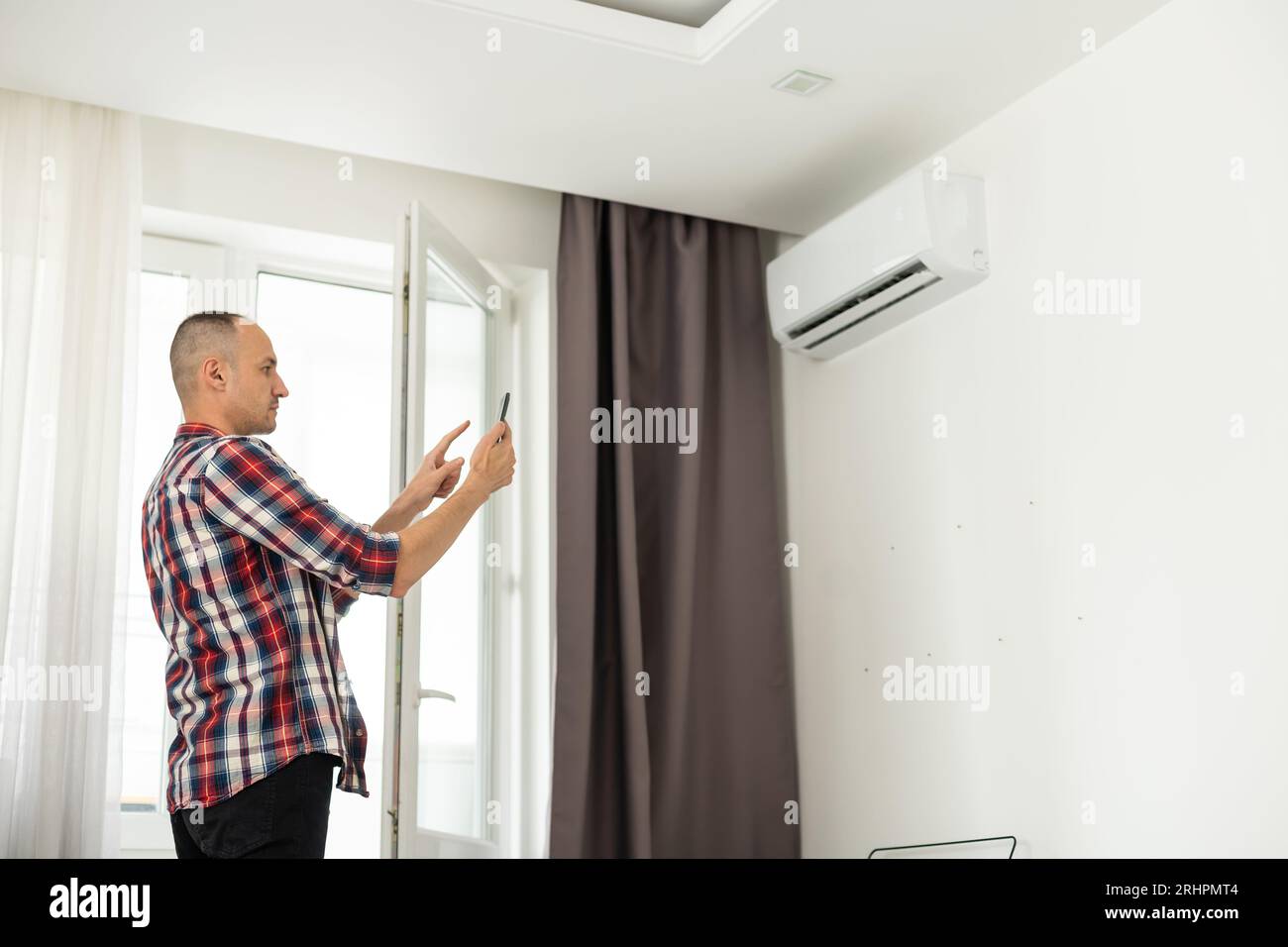 Full length young man wearing glasses holding using air conditioner ...