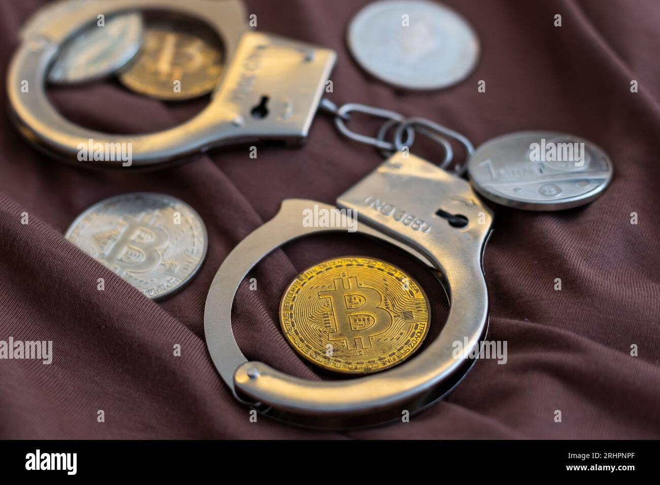 Bitcoins and handcuffs as an abstract symbol of crime that can hide a ...