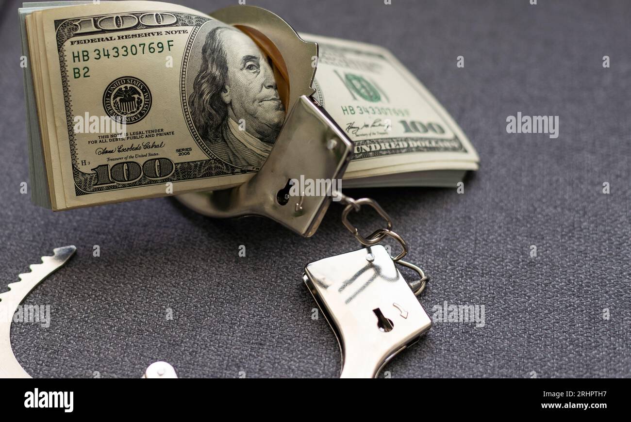 Banknotes dollars money and handcuffs isolated on black background ...